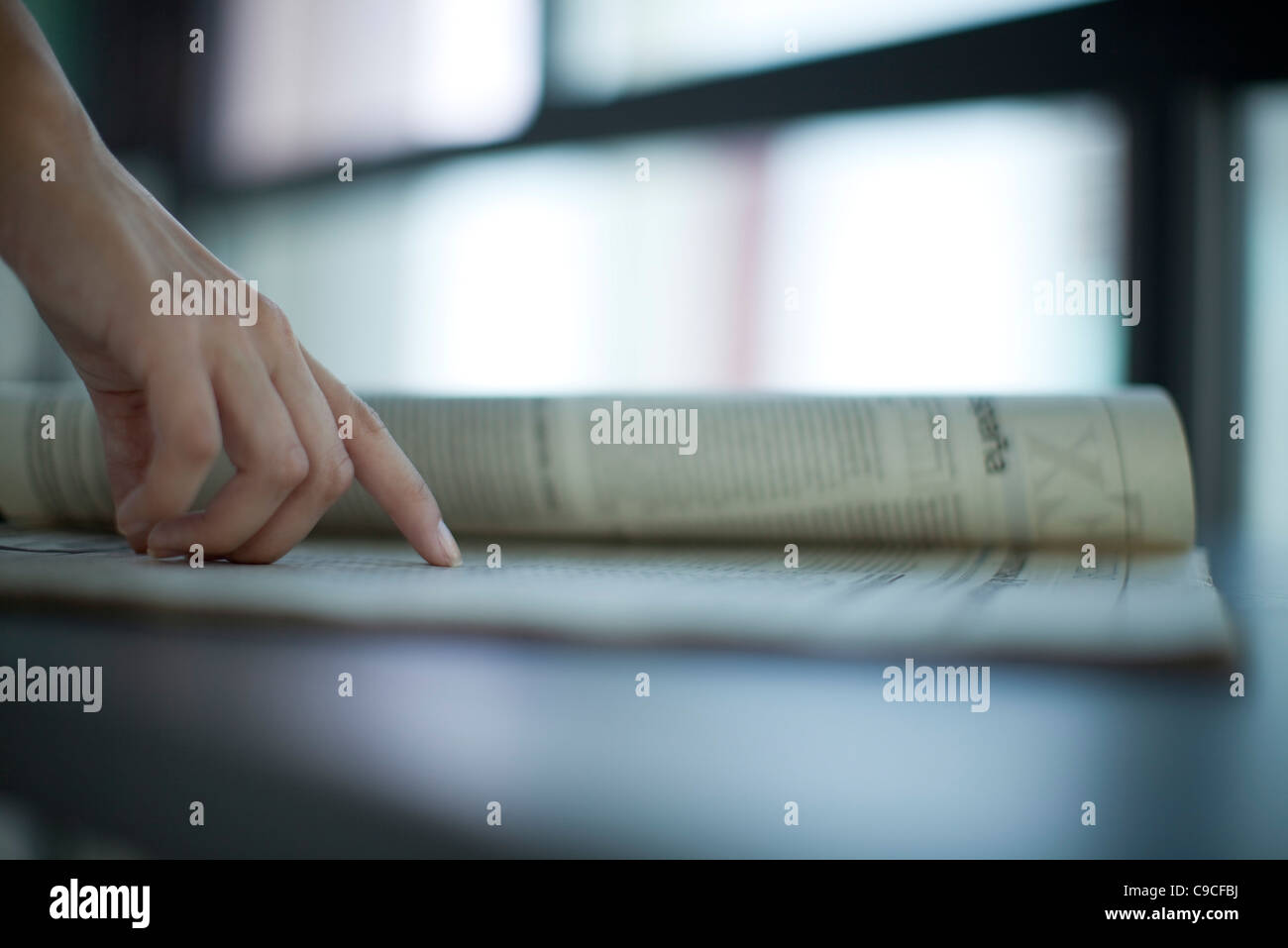 Hand pointing at newspaper, backlit, cropped Stock Photo - Alamy