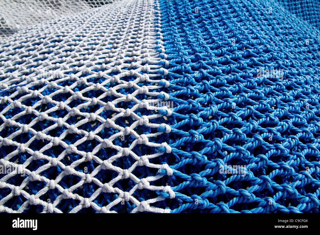 blue and white fishing nets with rope knots for trawling boats Stock ...