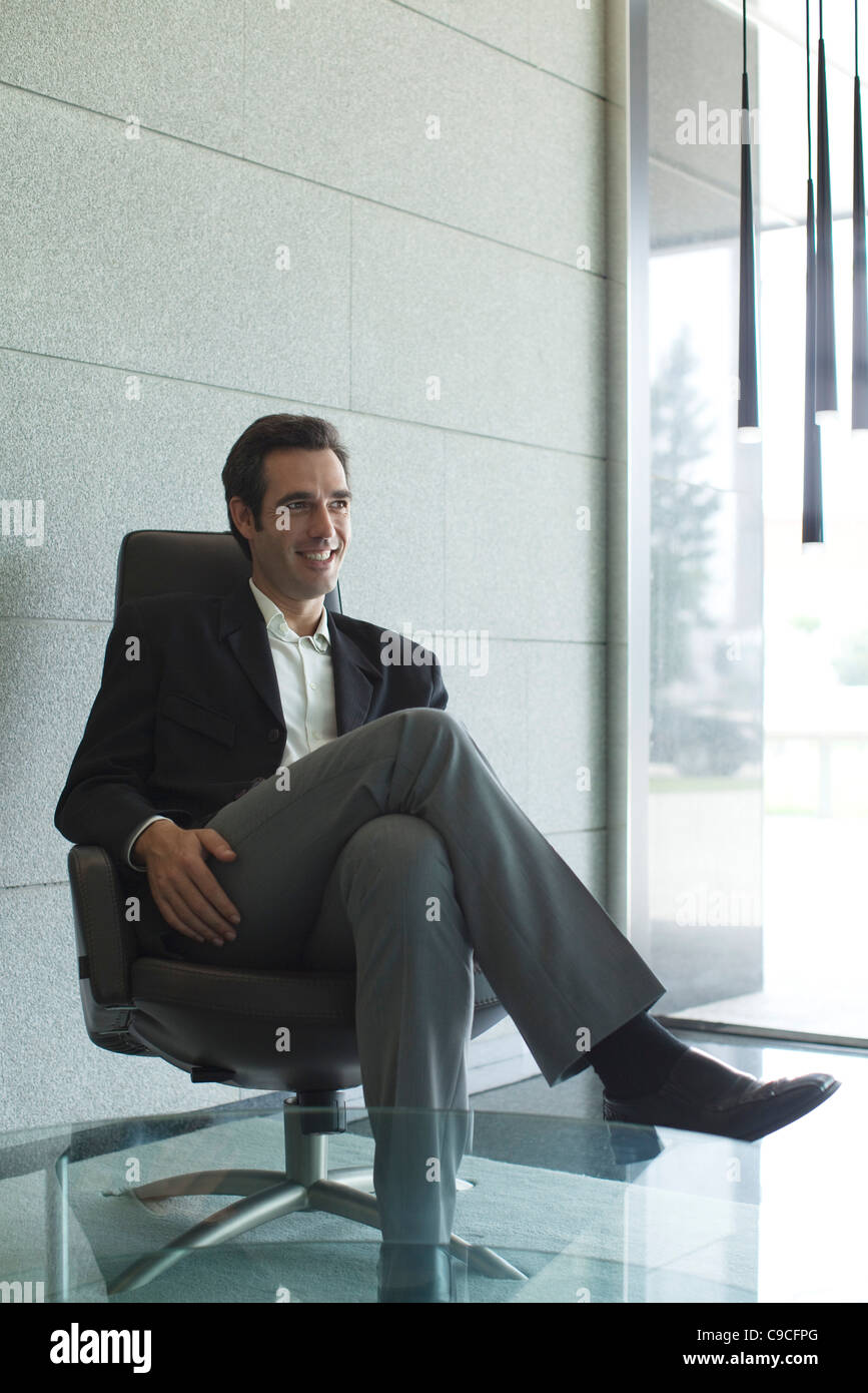 Executive sitting in lobby, backlit Stock Photo - Alamy