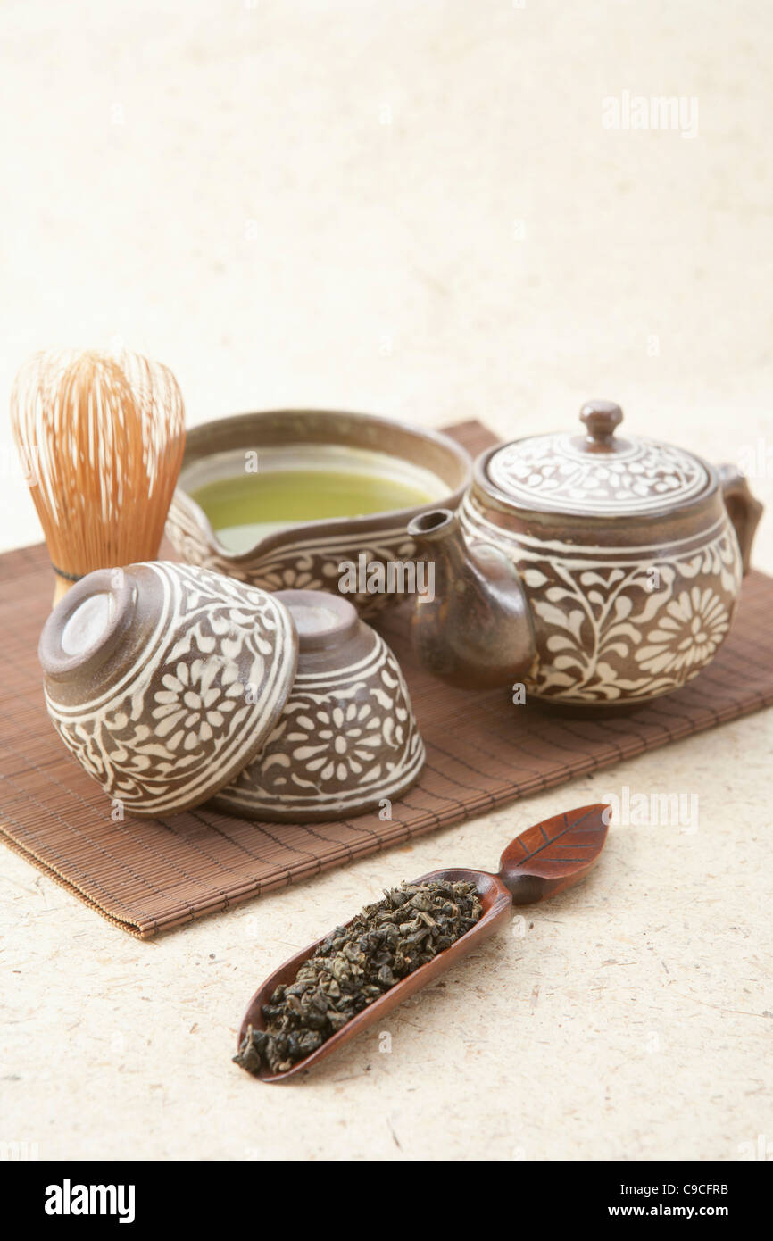 Classical tea set with green tea leaves Stock Photo - Alamy