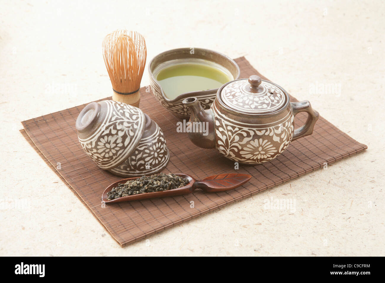 Classical tea set with green tea leaves Stock Photo - Alamy