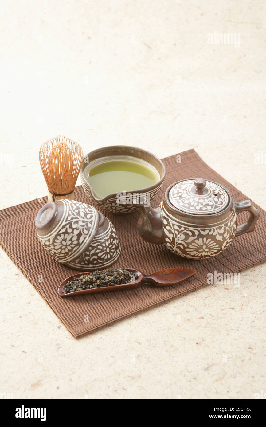 Classical tea set with green tea leaves Stock Photo - Alamy