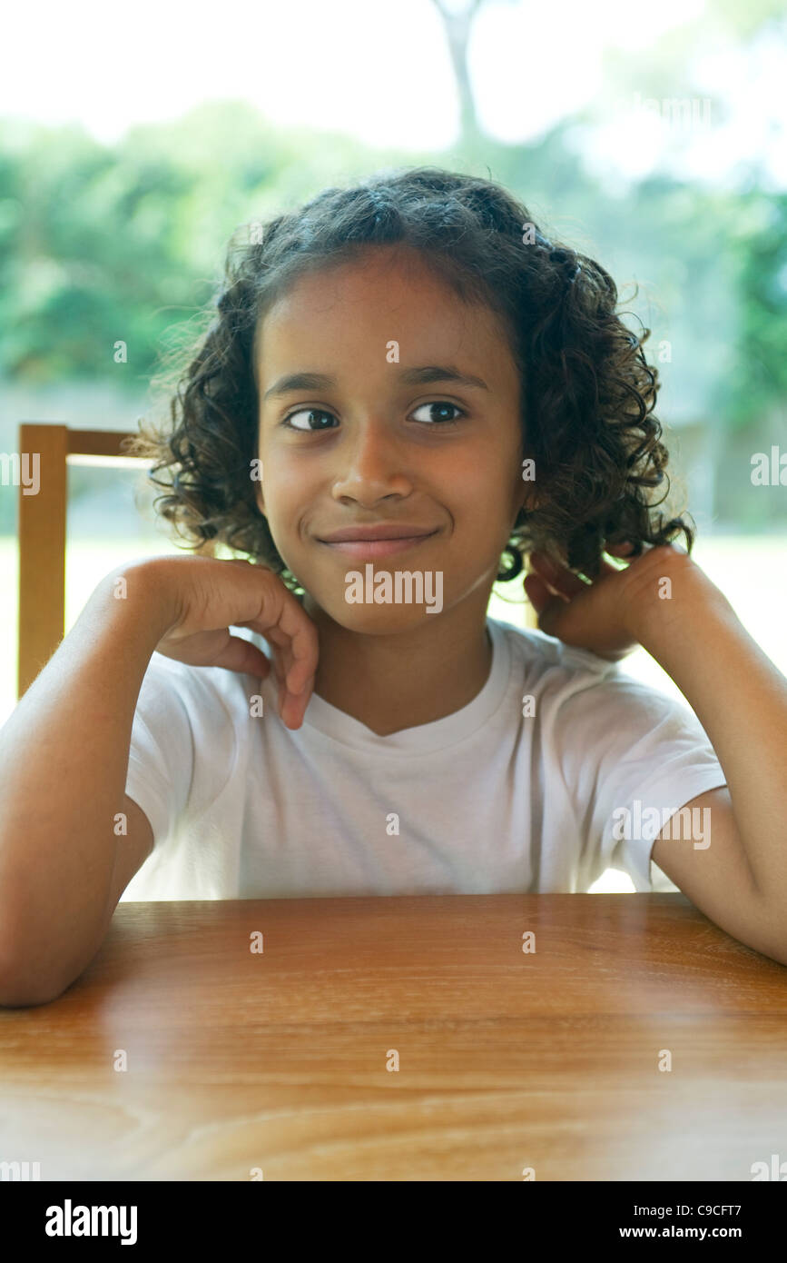Girl sitting at table, portrait Stock Photo - Alamy