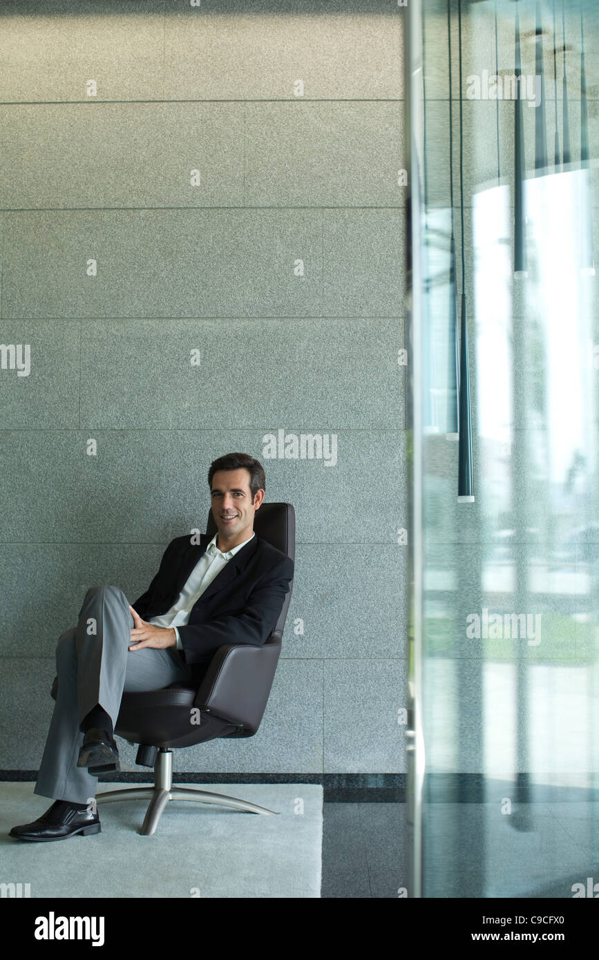 Executive sitting in lobby Stock Photo - Alamy