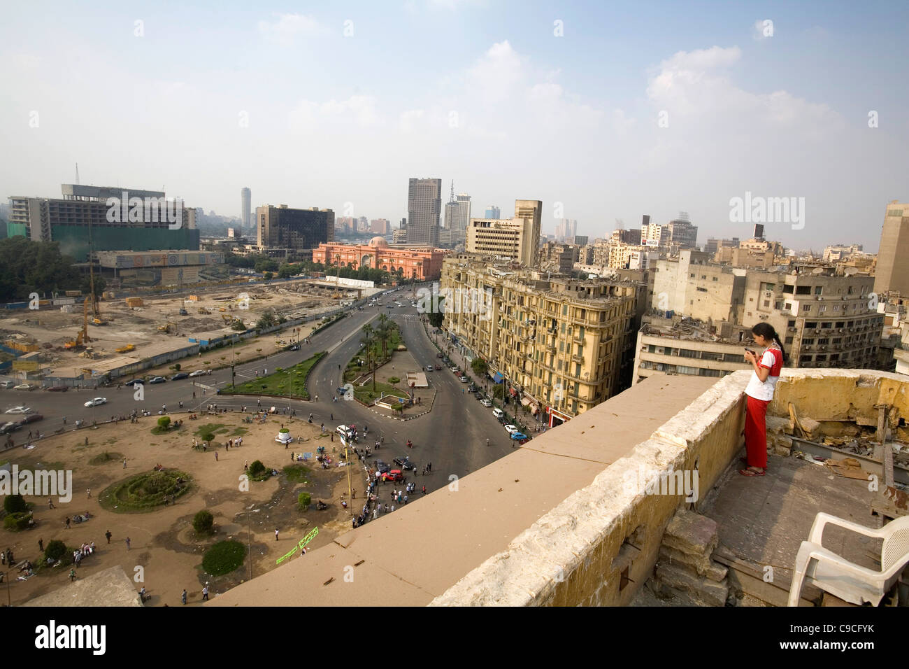 Young Egyptian girl taking picture from the top roof of her house ...