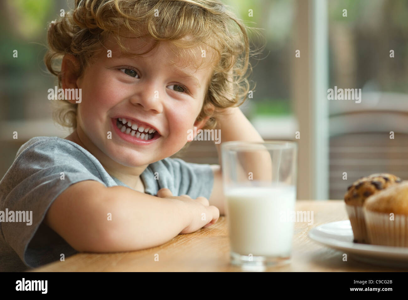 Little boy sitting at table with snack, portrait Stock Photo - Alamy