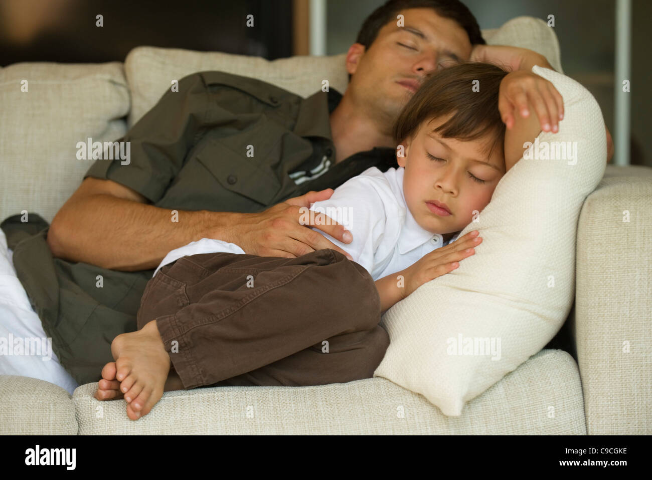 Father and son napping together on sofa Stock Photo - Alamy
