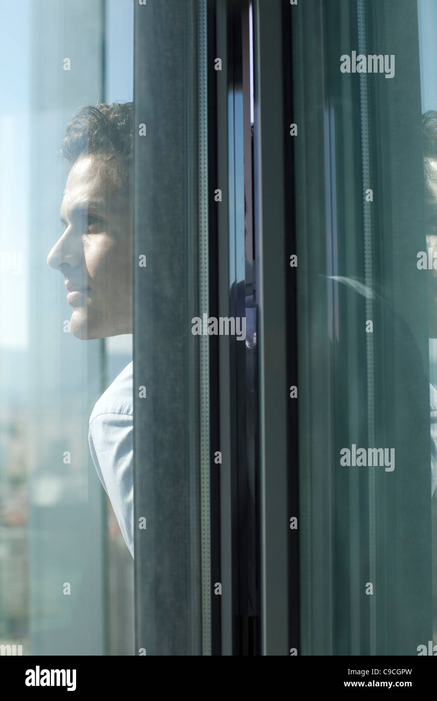 Man looking out of open window Stock Photo - Alamy