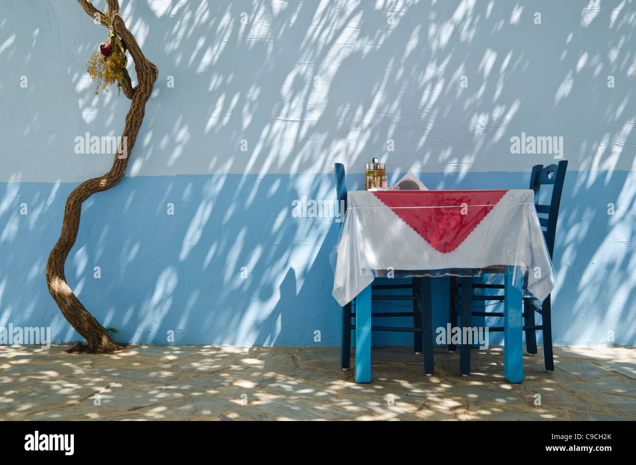 Shaded Greek taverna table in the old Horio of Symi Island, Greece ...