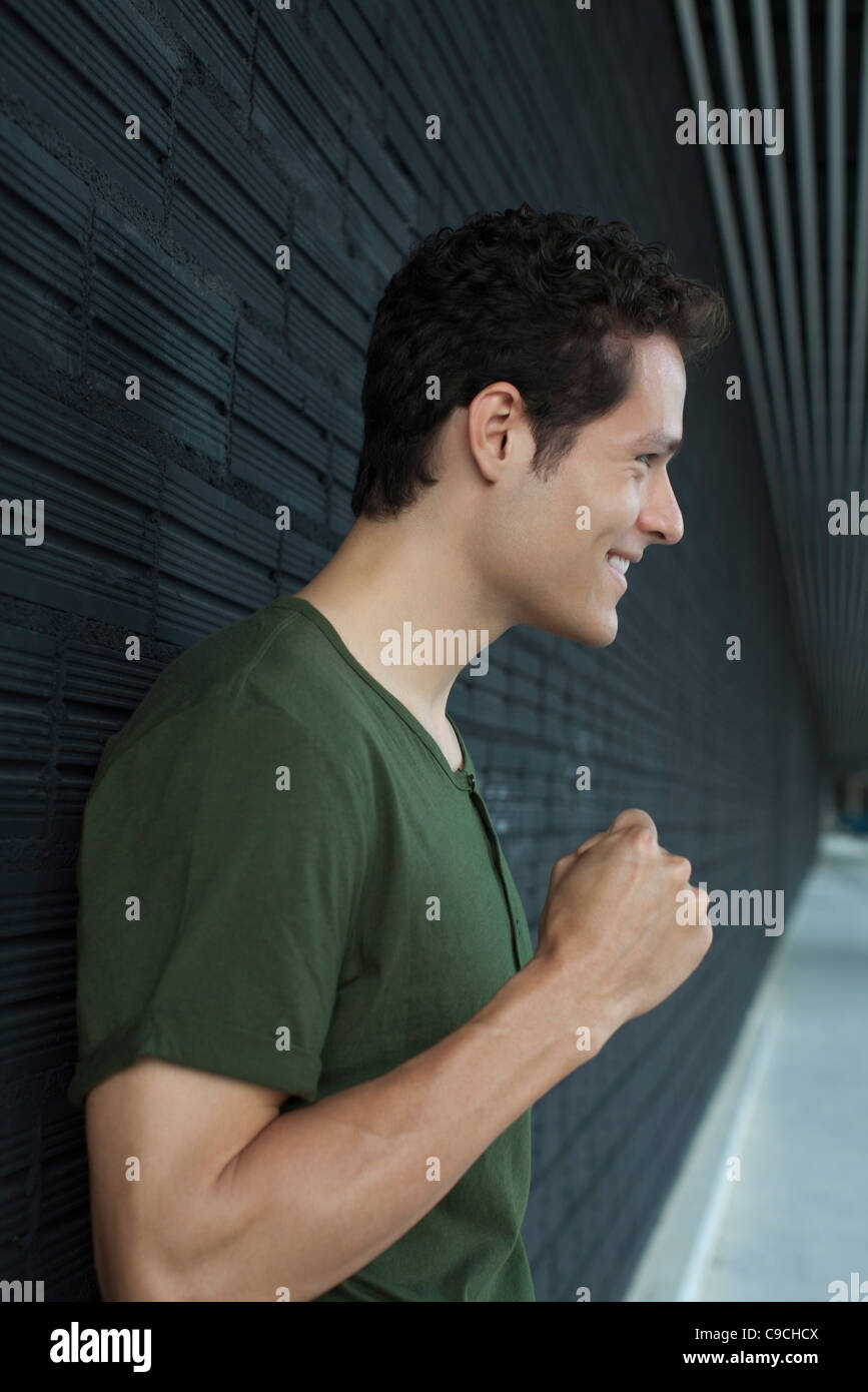 Smiling man holding up fist Stock Photo - Alamy
