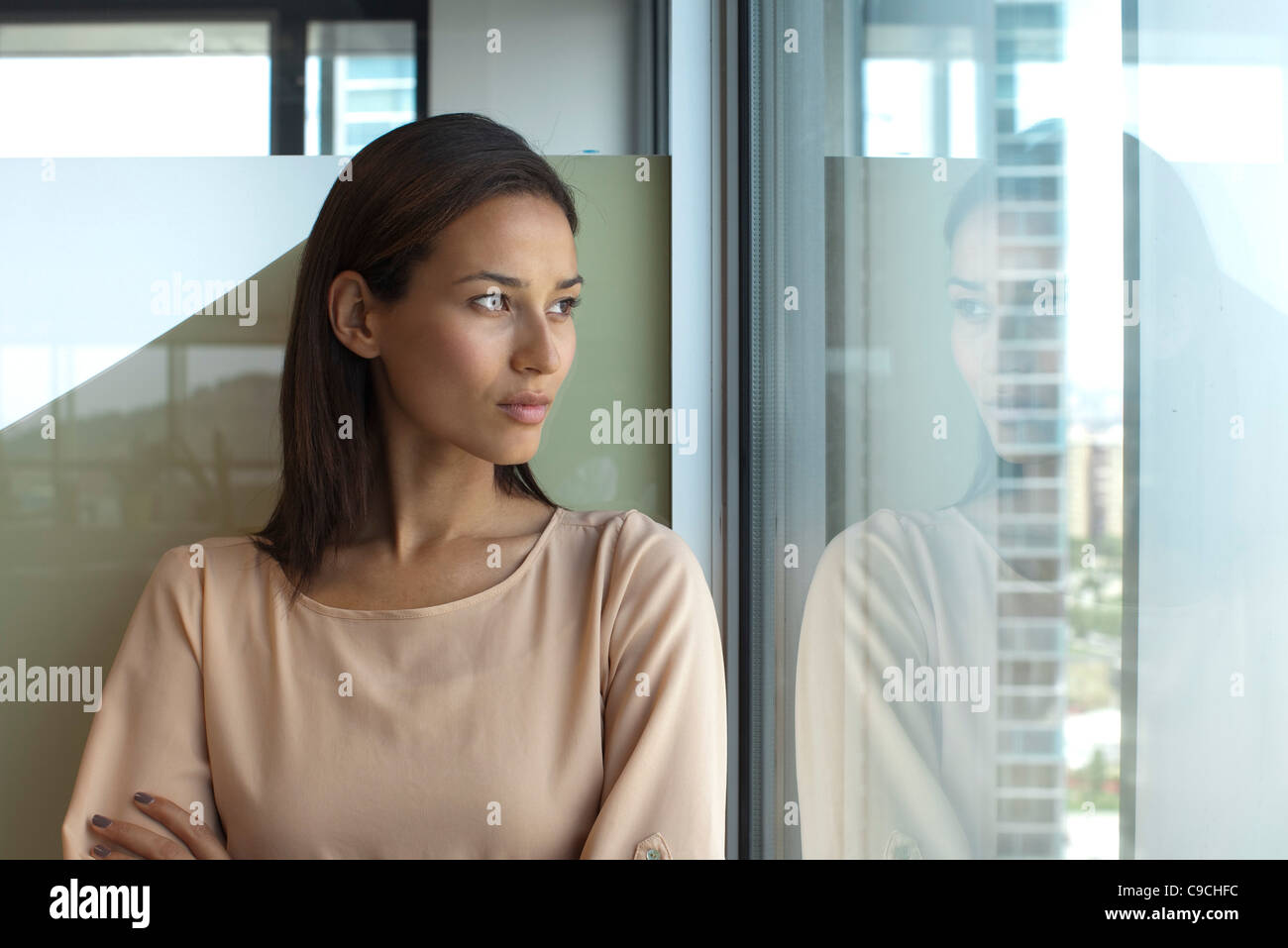 Woman looking out of window Stock Photo - Alamy