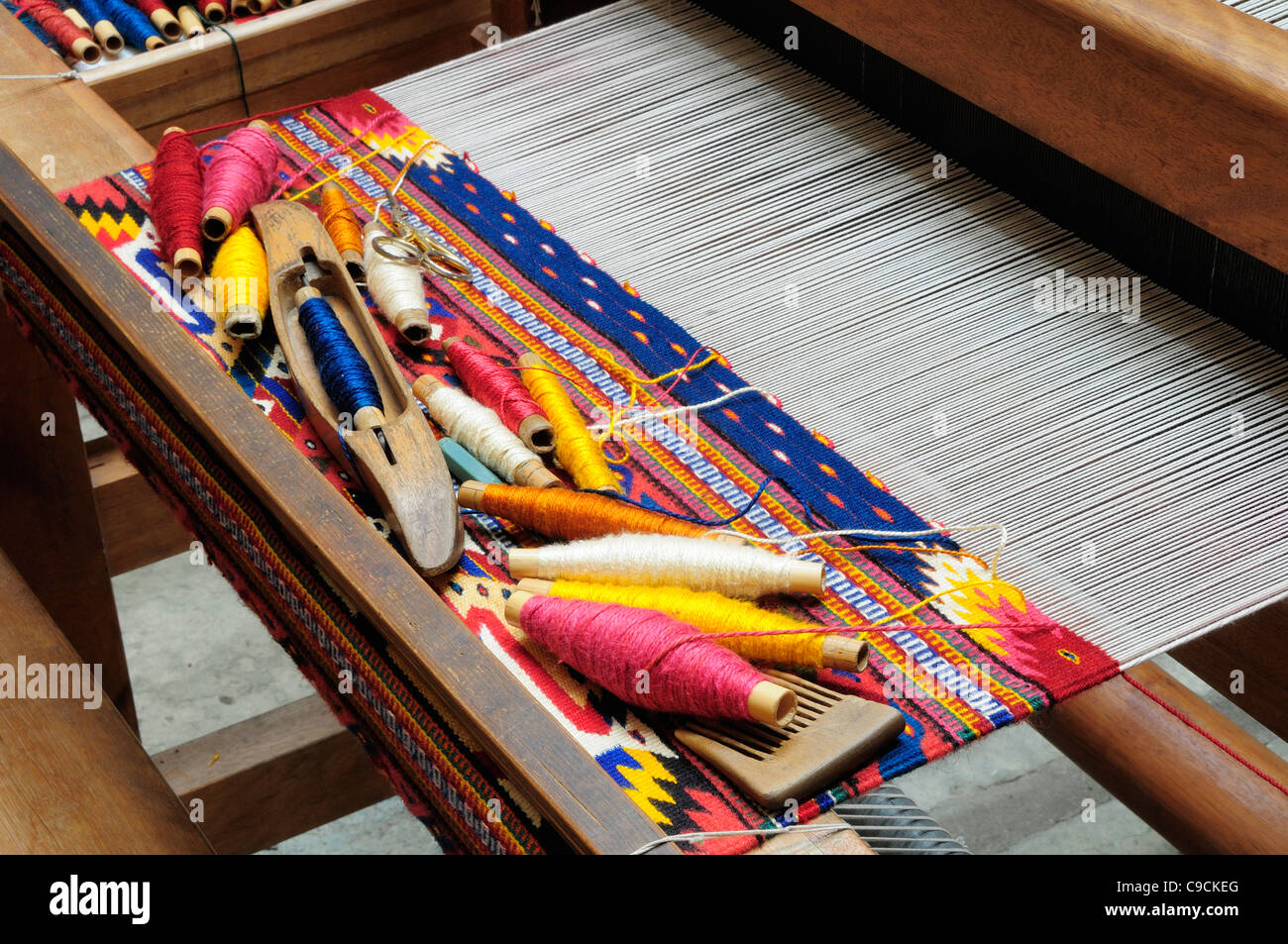 Mexico, Oaxaca, Spools of coloured wools on loom ready for weaving ...