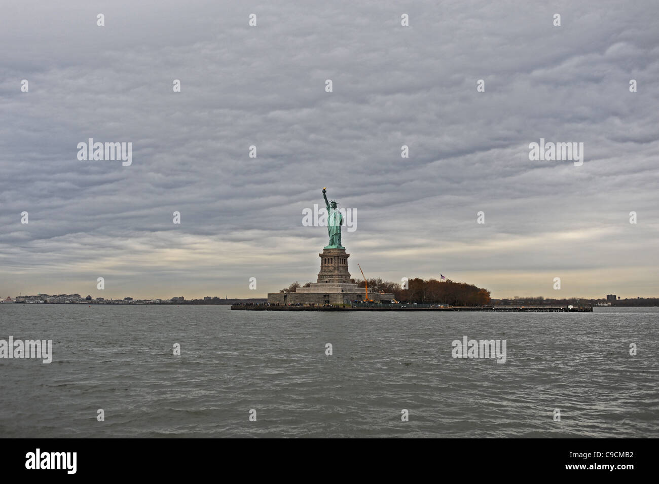 Statue of Liberty on dull grey day with dark skies Manhattan New York ...