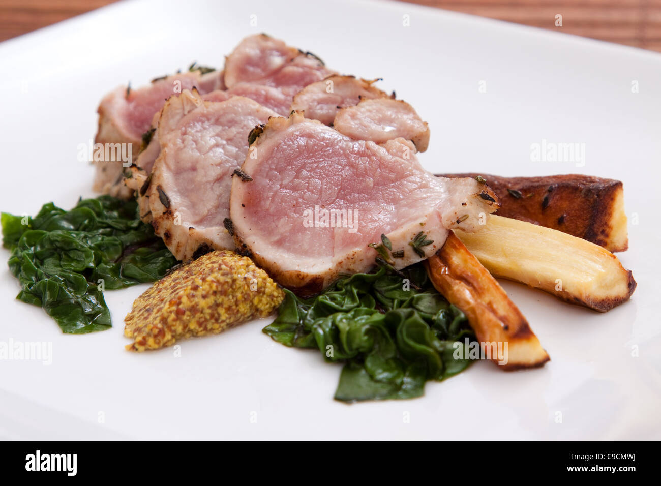 Sumptuous dinner of thinly sliced pork served with wilted spinach and ...