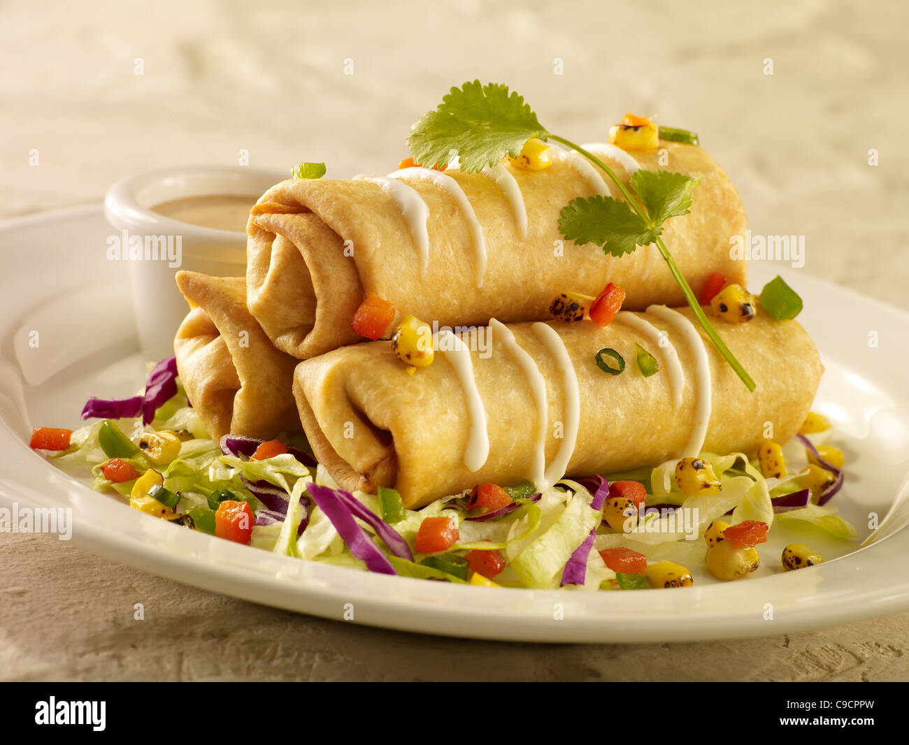 Mini chimichanga topped with sour cream and salsa fresca Stock Photo ...