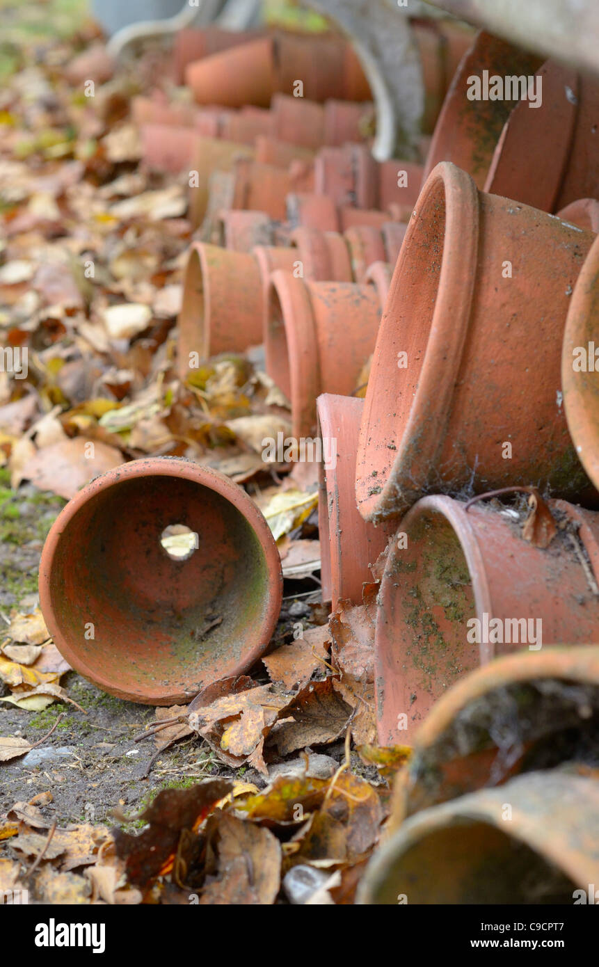Terracotta flowerpots stored under garden seat, Uk, November Stock ...