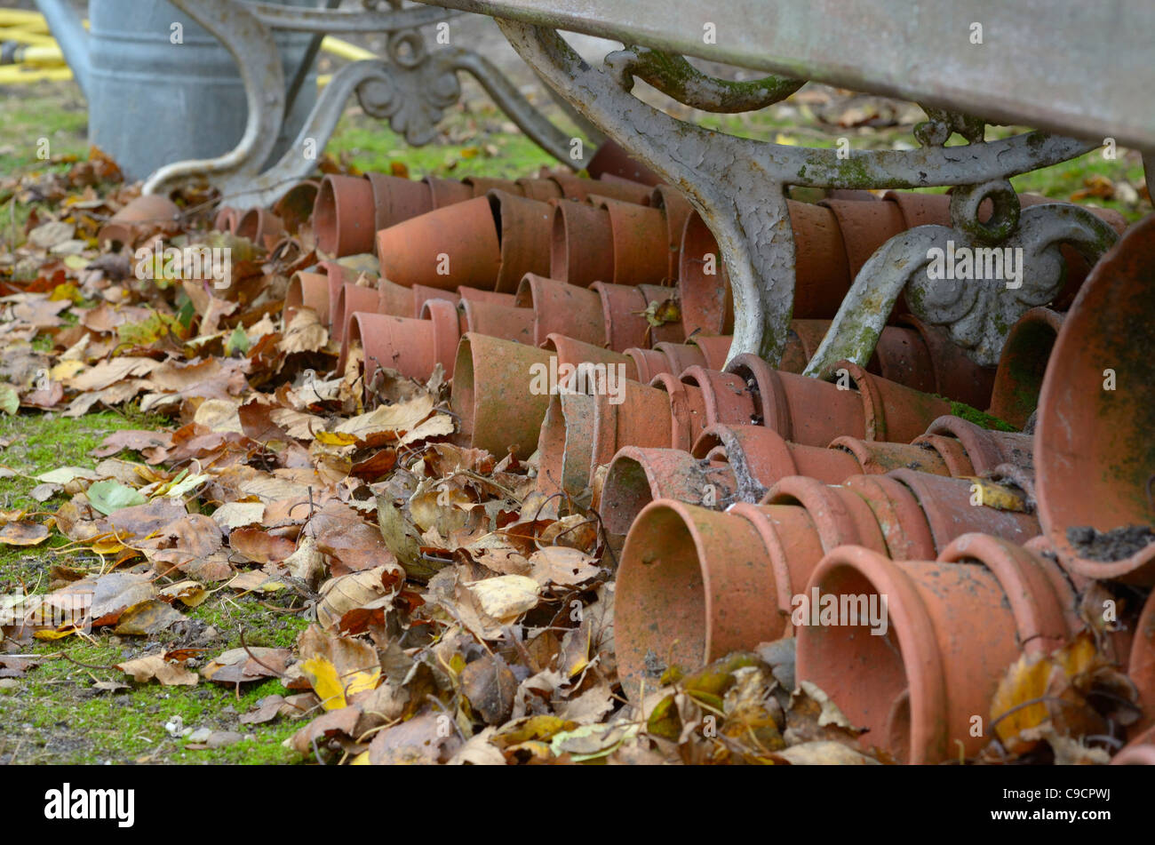 Terracotta flowerpots stored under garden seat, Uk, November Stock ...