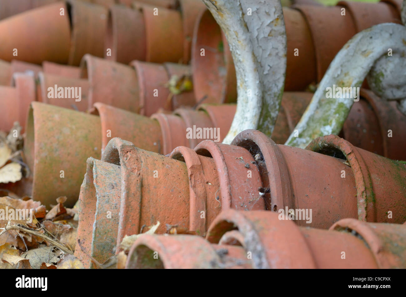 Terracotta flowerpots stored under garden seat, Uk, November Stock ...