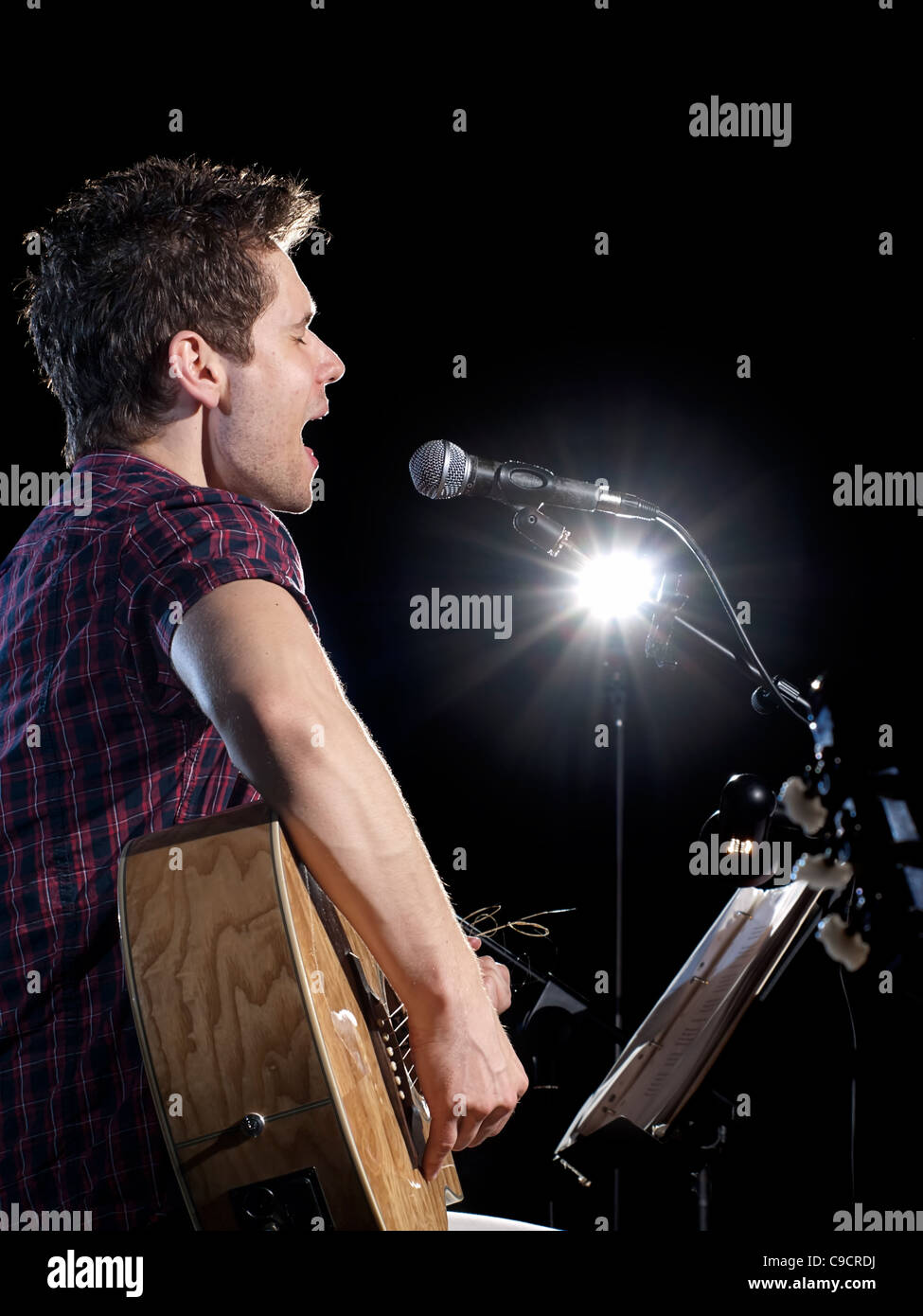 Guitarist Player Singing With Passion On The Stage For Entertainment music concert Themes Stock guitarist-player-singing-with-passion-on-the-stage-for-entertainment-music-concert-themes-stock