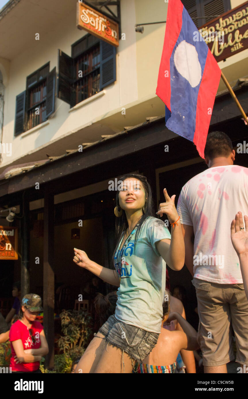 Lao girl dancing by Lao flag, during water fight to celebrate Lao New ...