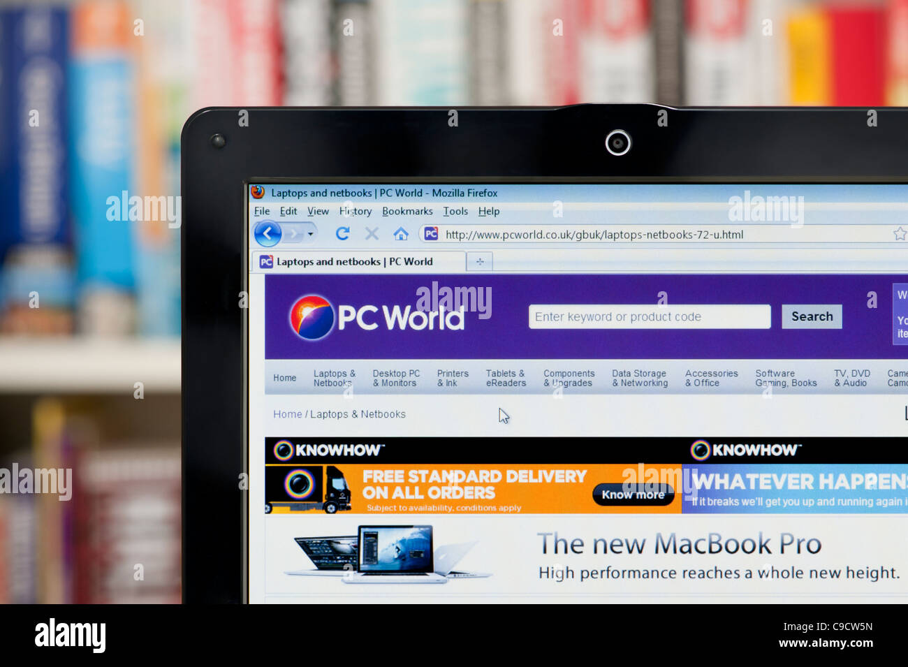 The PC World website shot against a bookcase background (Editorial use ...