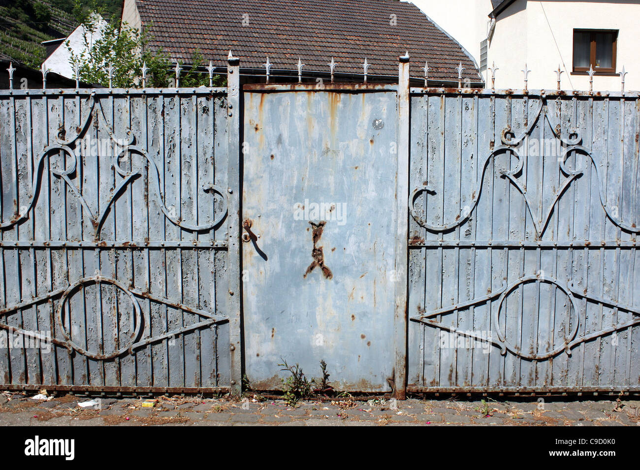 Old blue rusty fence with entrance Stock Photo - Alamy