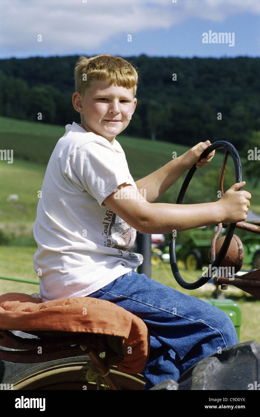 Portrait of a boy driving a farm tractor Stock Photo - Alamy
