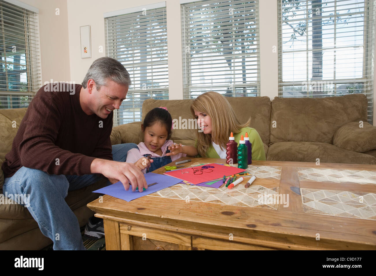 Parents helping their daughter to draw Stock Photo - Alamy