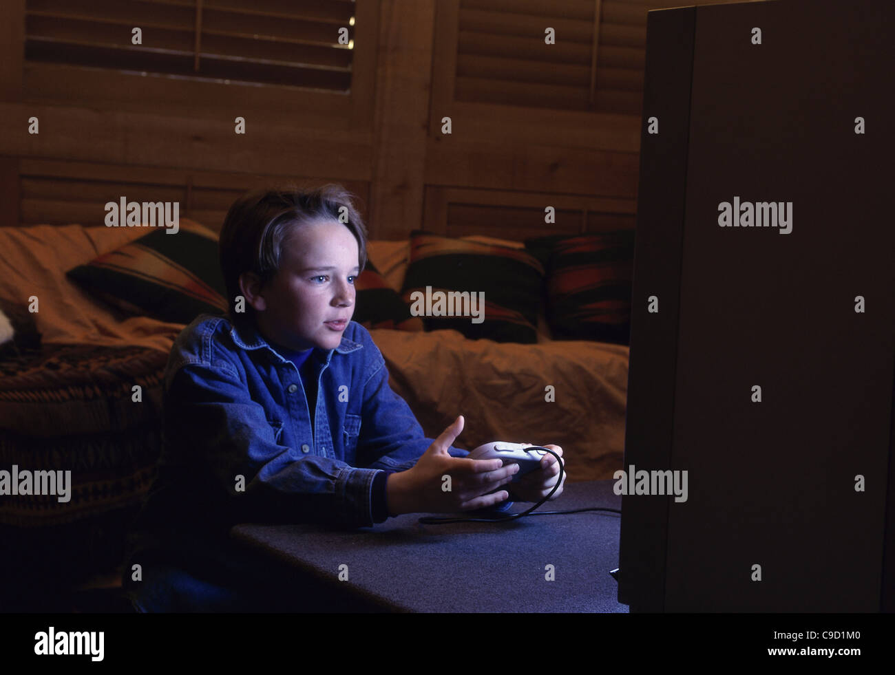 Side profile of a boy operating a game joystick Stock Photo - Alamy
