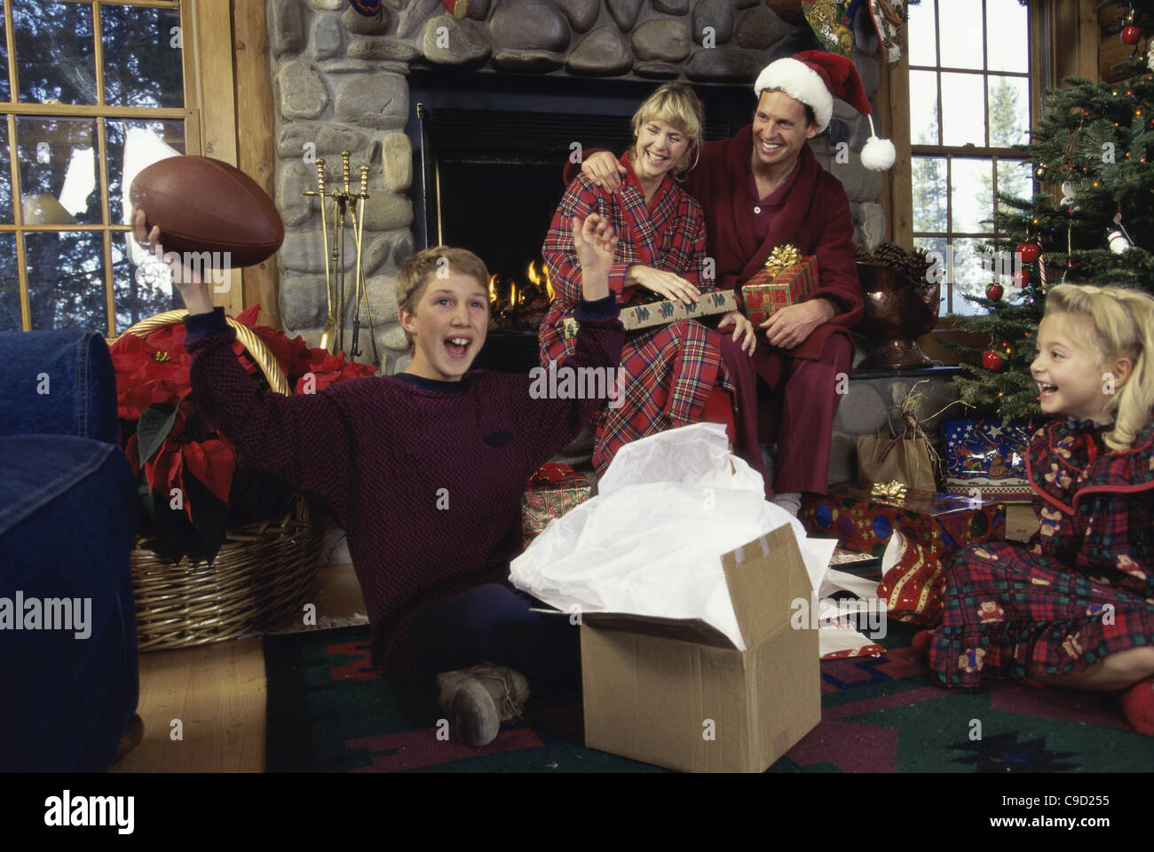 Son holding a rugby ball while his parents watch Stock Photo - Alamy