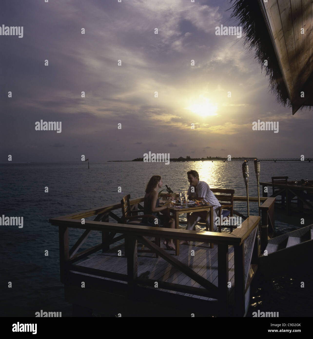 Young couple sitting together at a dining table, Maldives Stock Photo ...