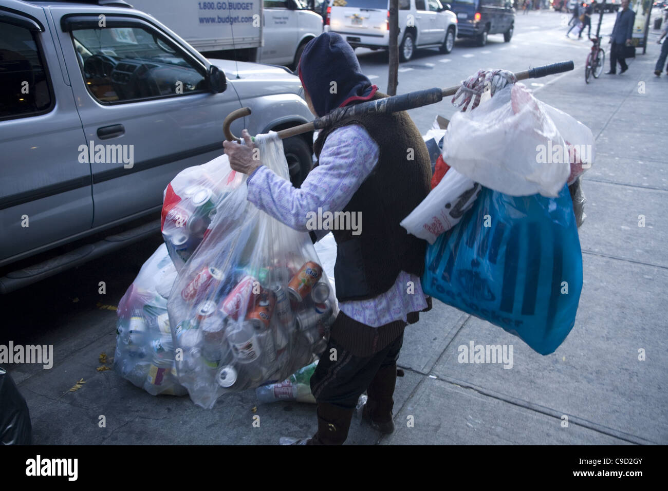 Woman on the street in NYC collecting empty soda cans and bottles to ...