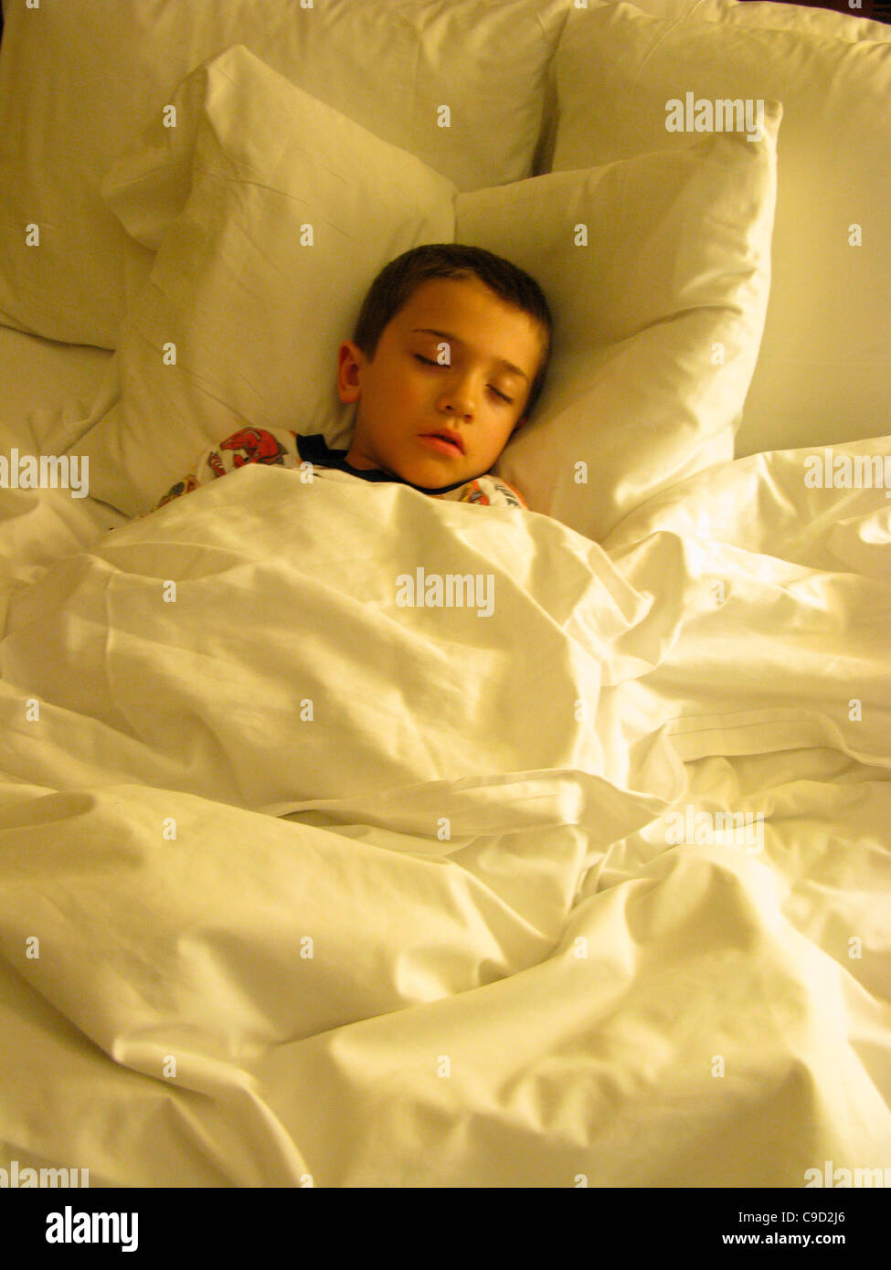 Boy sleeping in large bed Stock Photo - Alamy