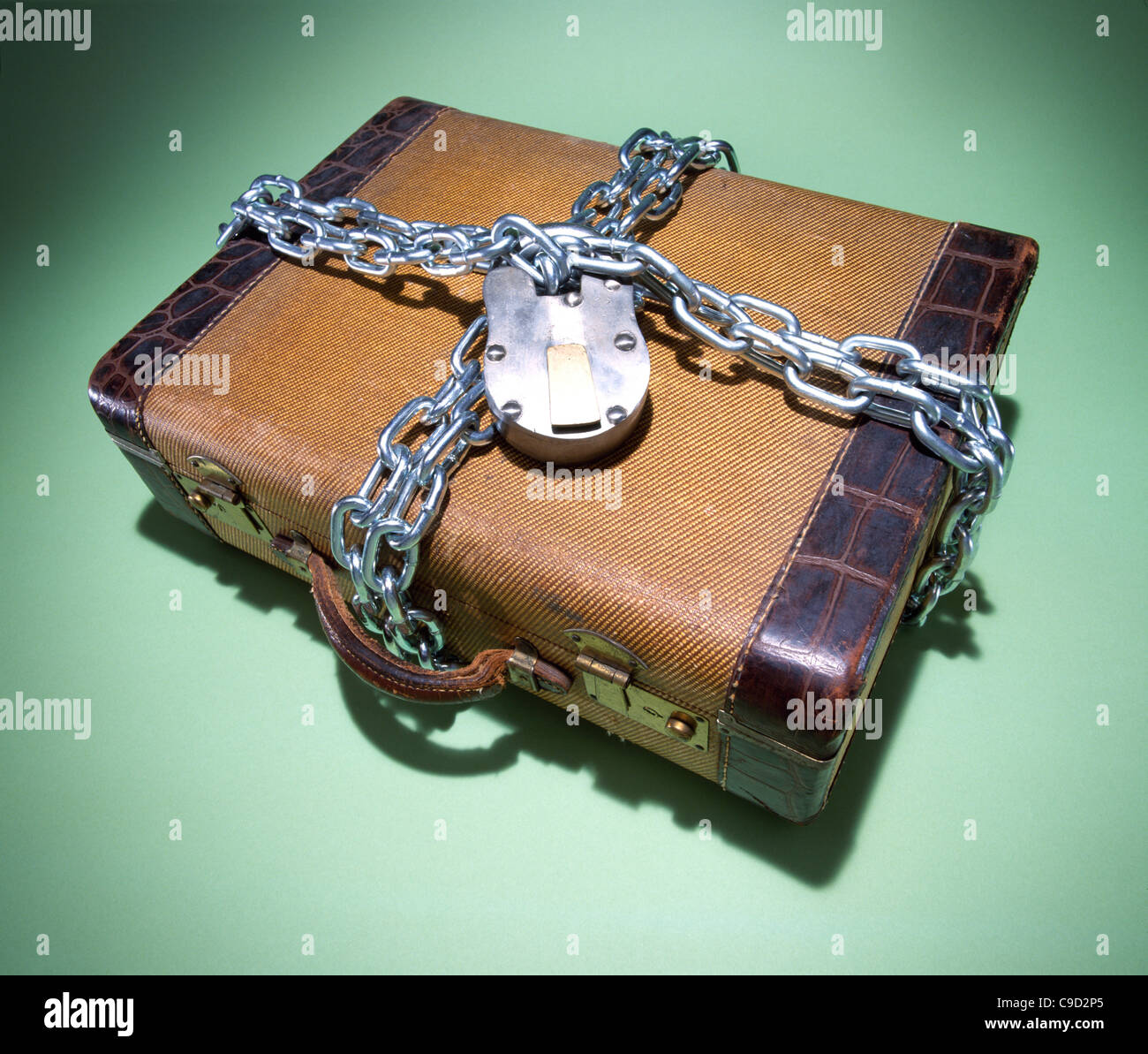 Antique suitcase wrapped with chain and padlock Stock Photo - Alamy
