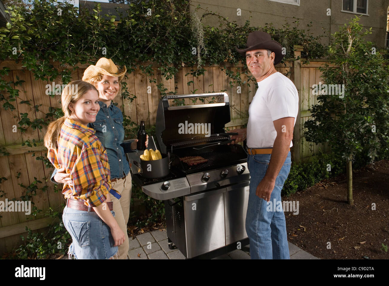 Portrait of a family standing near barbeque grill Stock Photo - Alamy