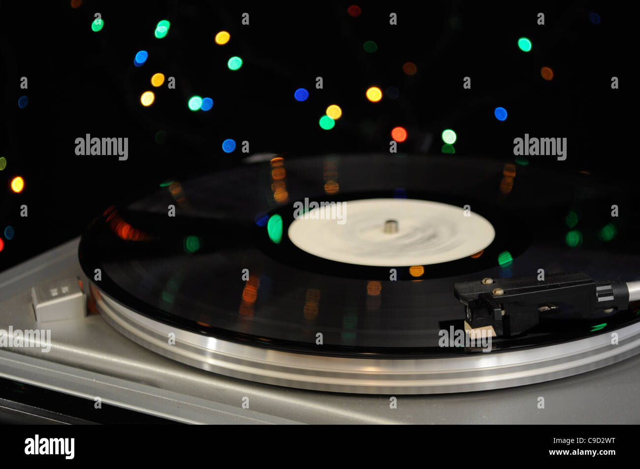 Old record player in action on a black background with colorful lights ...