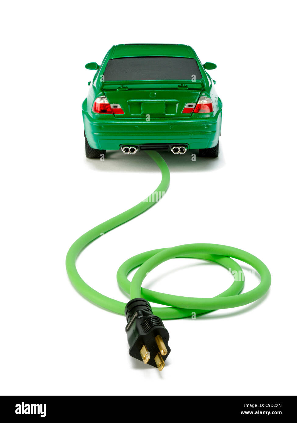 Small green automobile with a green electrical power cord and black ...