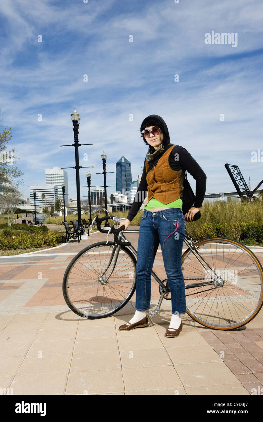 Portrait of a young woman standing with her bicycle Stock Photo - Alamy