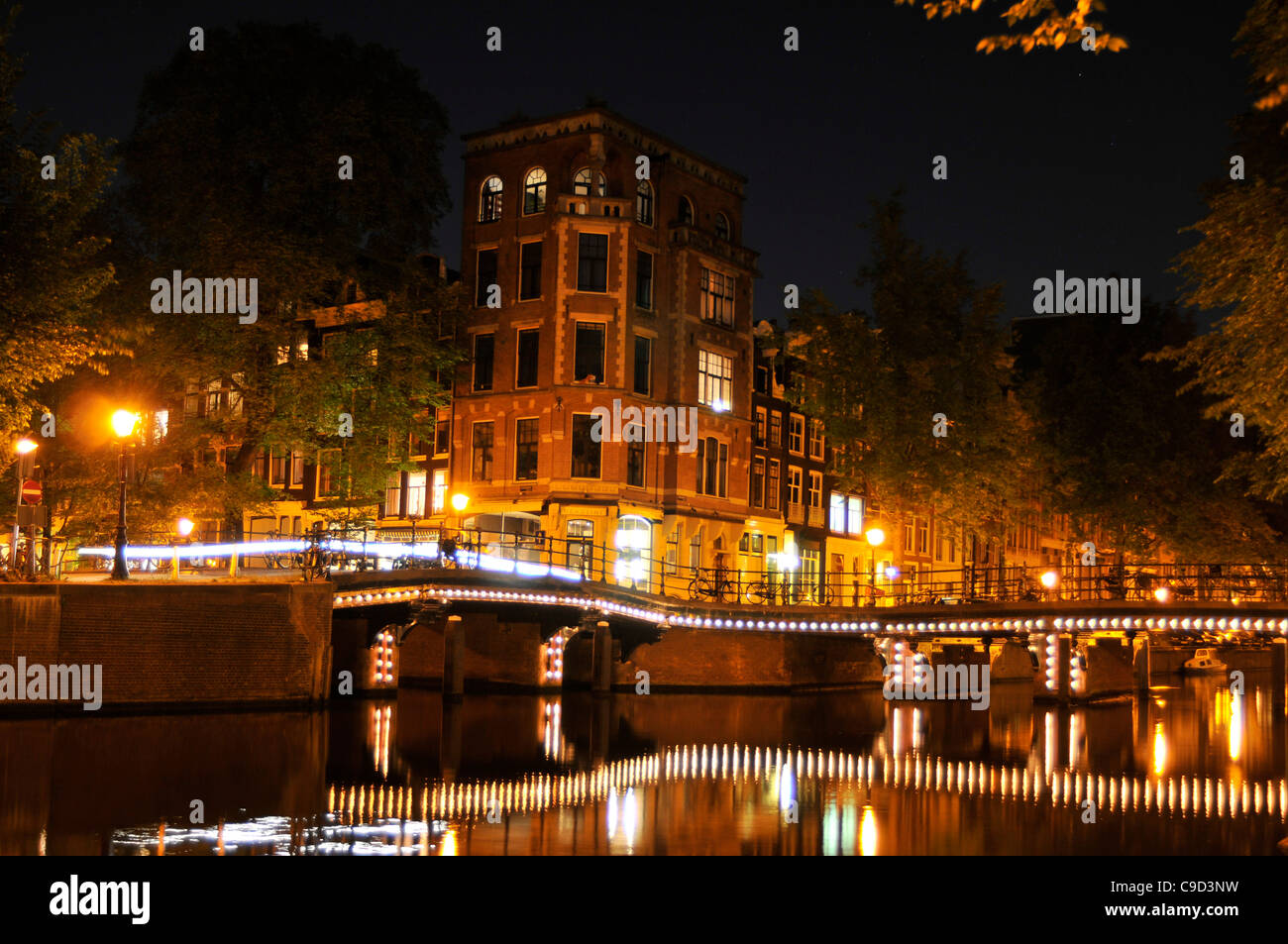 Bridge with buildings lit up at night, Amsterdam, Netherlands Stock Photo - Alamy