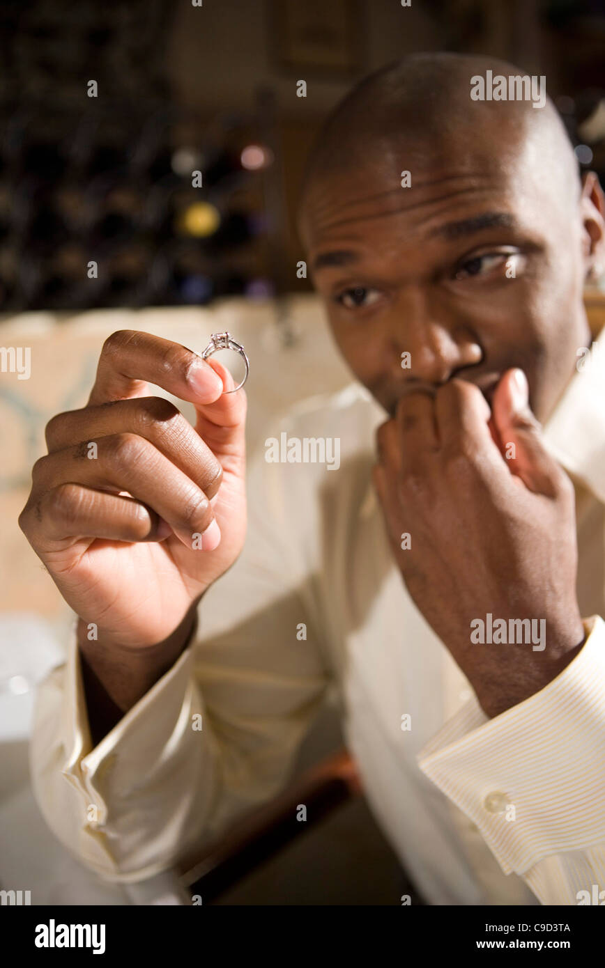 Young African American man nervously holding and looking at an ...