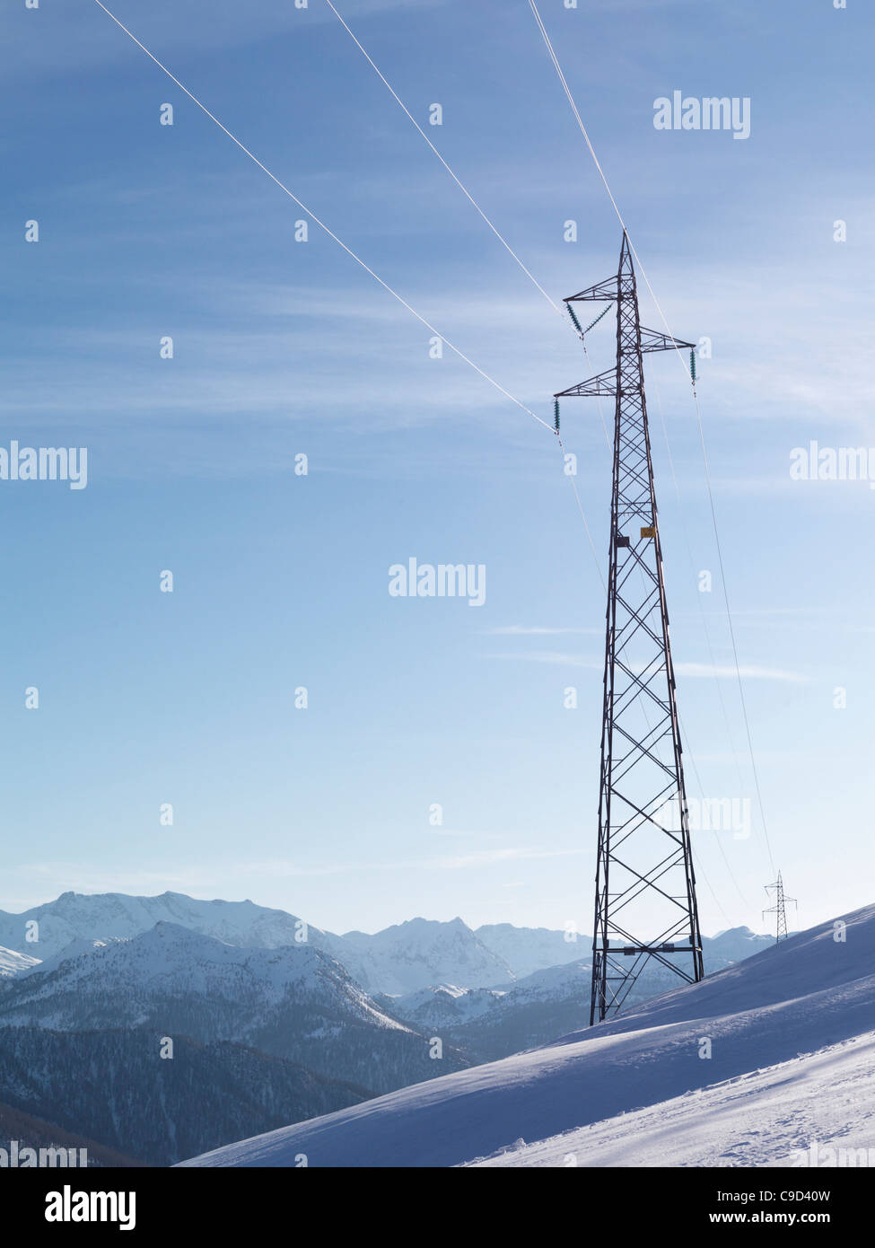 Italy, Piedmont, Power pylons rise above snow covered slopes and ...
