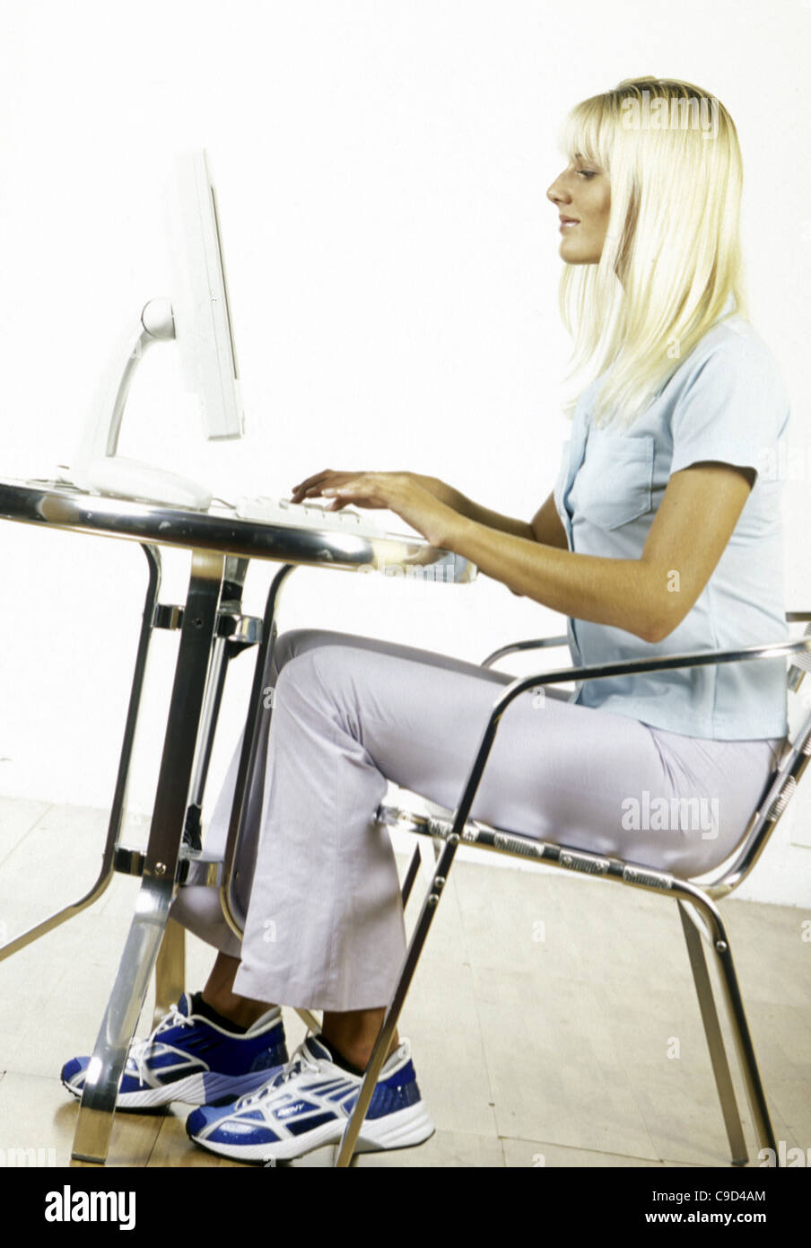 Side profile of a young woman sitting using a laptop Stock Photo - Alamy