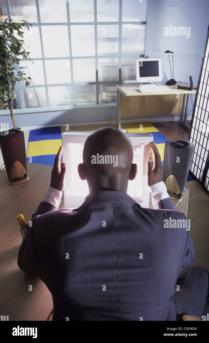 Rear view of a businessman sitting in front of a computer Stock Photo ...