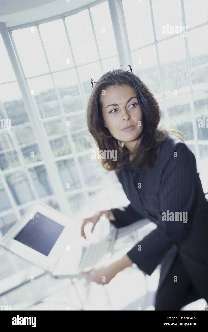 Side profile of a businesswoman sitting in front of a laptop Stock ...