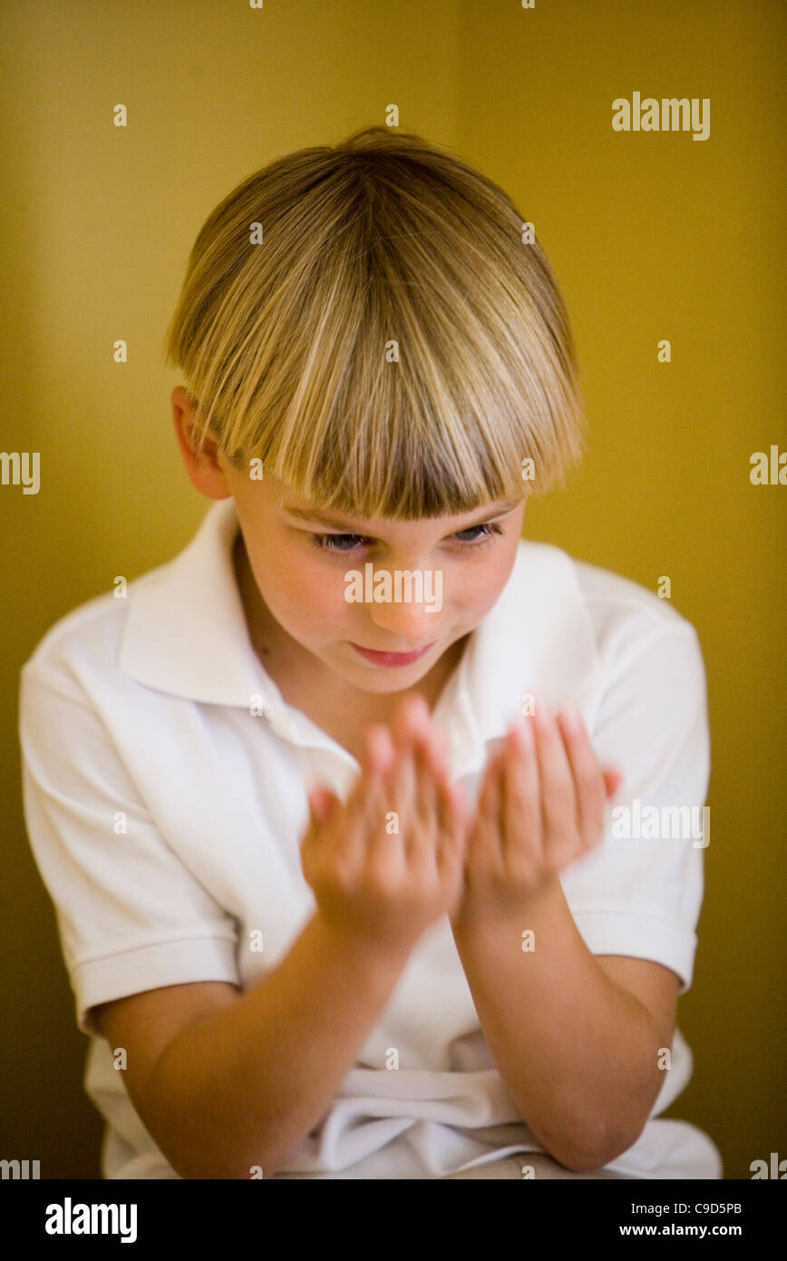 Boy staring at hands Stock Photo - Alamy