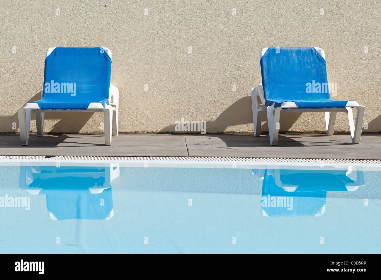 Two empty blue pool chairs at the pool Stock Photo - Alamy
