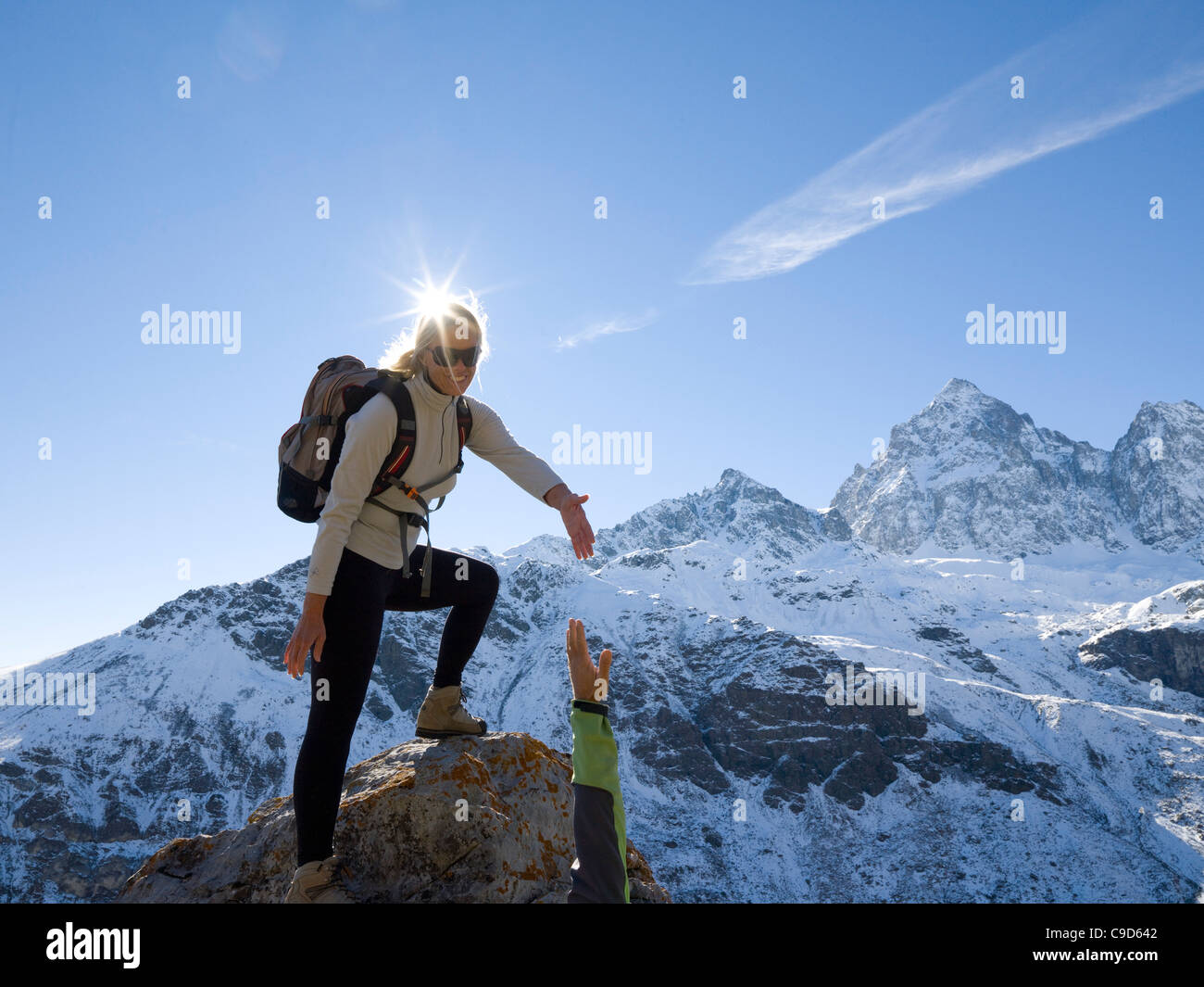 Italy, Piedmont, Female mountaineer offering help to companion Stock ...