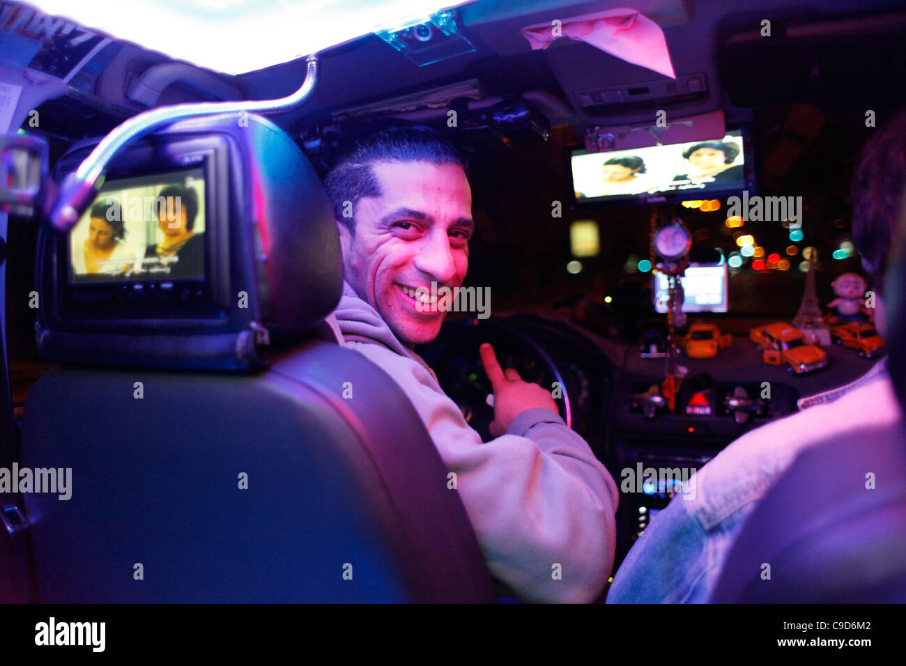 A taxi driver driving a decorated taxicab with electronic gadgets in ...