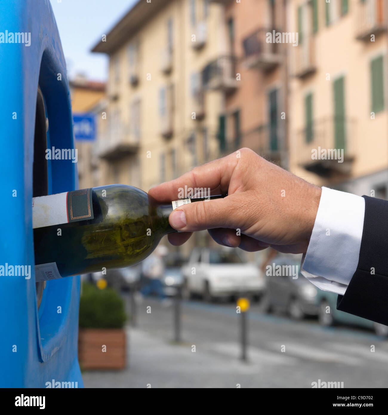 Italy, Piedmont, Businessman dropping bottle into recycling bin Stock ...