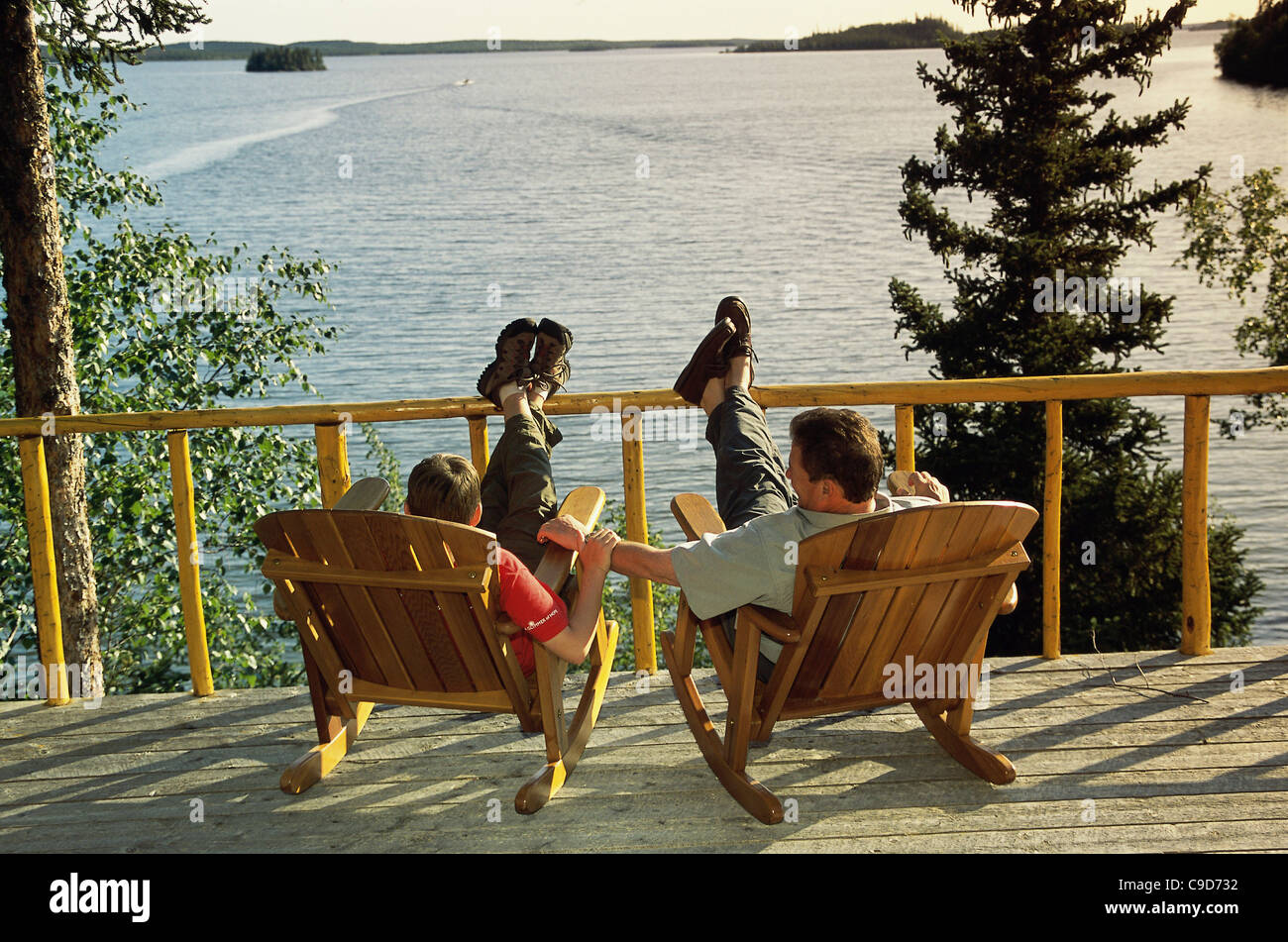Father and son sitting together on rocking chairs, Canada Stock Photo ...